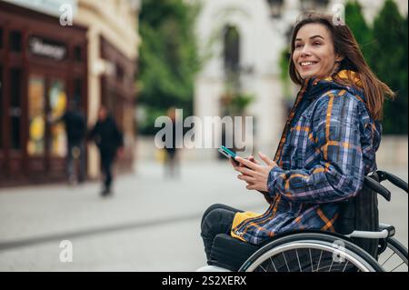 Young beautiful woman with disability who uses a wheelchair using a ...