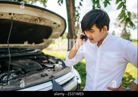 A man called a mechanic to fix the car because the car broke down Stock ...
