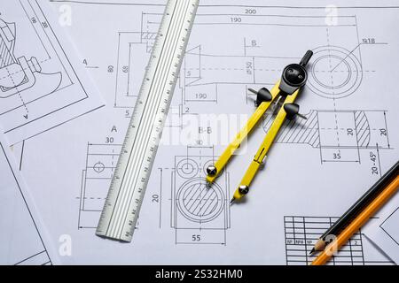 Different engineering drawings, pencils, ruler and divider on wooden ...