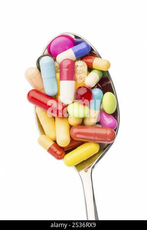 Many colourful tablets on a spoon. Symbolic photo for tablet addiction ...