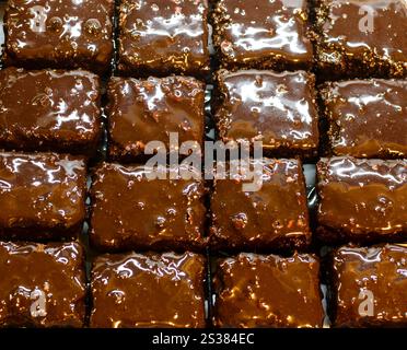 Baked pieces of chocolate brownie pie on black table, delicious dessert ...