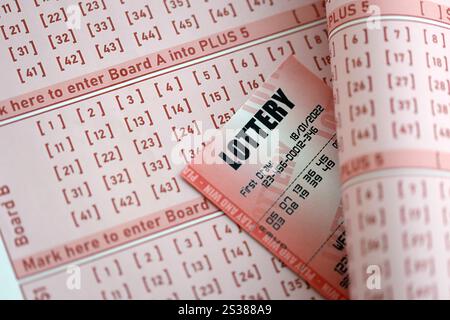 Red lottery ticket lies on pink gambling sheets with numbers for ...