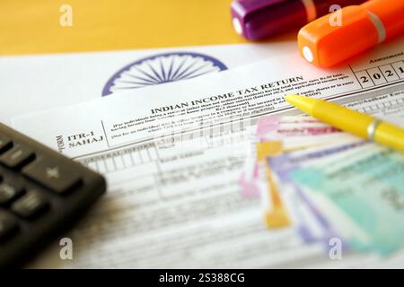 Indian income tax return blank form with pen and indian rupees bills on ...