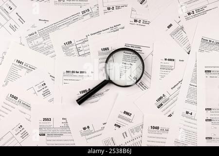 Magnifying glass lying over heap of paper documents. Investigation and ...