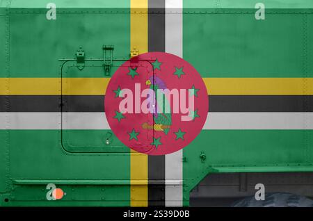 Dominica flag depicted on side part of military armored tank close up ...