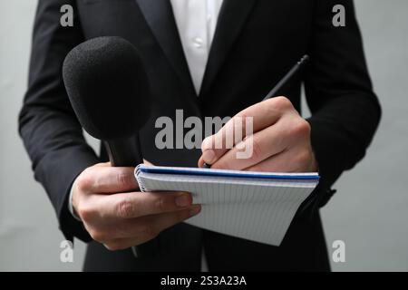 Journalist with microphone on grey background, closeup Stock Photo - Alamy