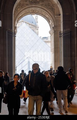 Visitors explore the iconic glass pyramid at the Louvre Museum in Paris ...