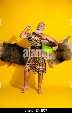 Photo of strong caveman hunter hold basket with animal skin raise hands ...