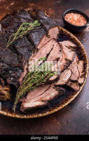 Roast Venison leg, baked meat of roe deer with bone on a tray with ...