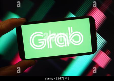 In this photo illustration, the Grab Holdings logo seen displayed on a ...