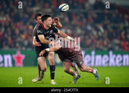 Saracens' Fergus Burke is tackled by Munster's Tom Farrell (left) and ...