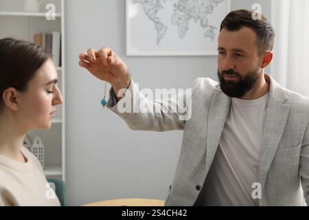 Psychologist using pendulum while working with patient during hypnosis ...