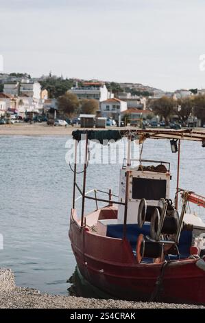 Fishing boats anchored at a pier in a small Greek village, gently ...
