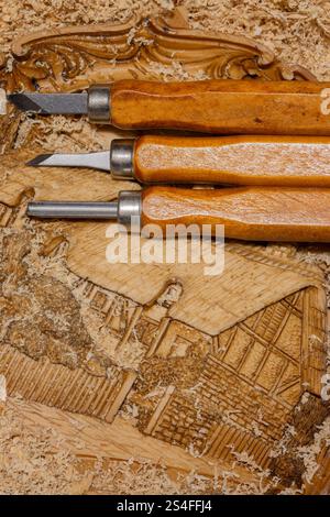 Carved ornate handmade wooden plaque with precision wood chisels on a ...