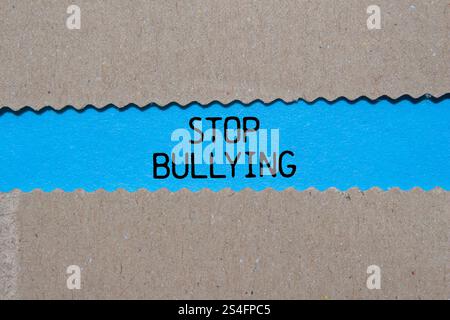 Stop bullying message written on ripped torn purple paper on black ...