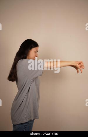Serious woman showing double thumbs down gesture, expressing ...