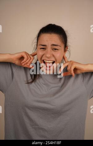 A universal symbol of salvation from auditory overload. Her gesture ...