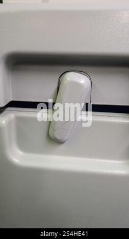Airplane tray table lock. Closeup of passenger hand opening and closing ...