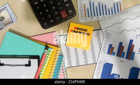 Concept of bridge financing write on sticky notes isolated on Wooden ...