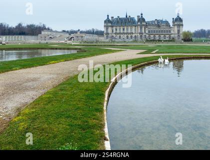 The Chateau de Chantilly (France) and swans in pond. The Grand Chateau ...