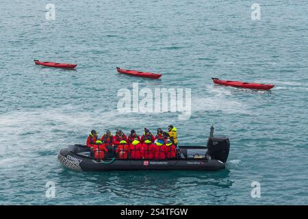Tourists on zodiac being taken ashore at Kvanefjord, Greenland in July ...