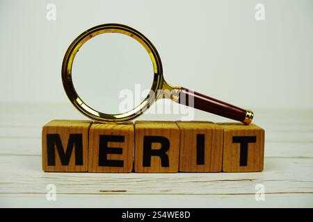 Merit with wooden blocks alphabet letters on green background Stock ...