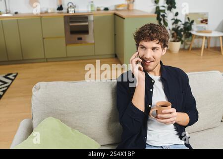 Curly-haired young man relaxes outdoors in a fashionable summer ...