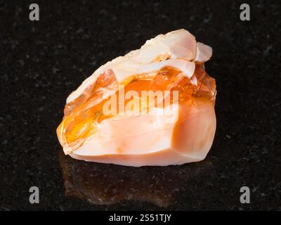 Natural noble opal on a black background. Noble opals are dark gray ...