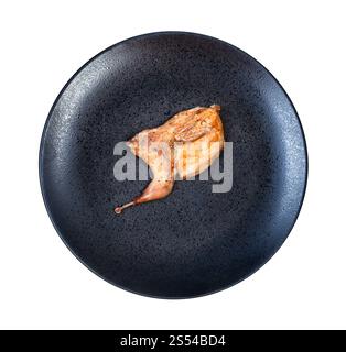top view of half of fried quail with crossed fork and knife on black ...