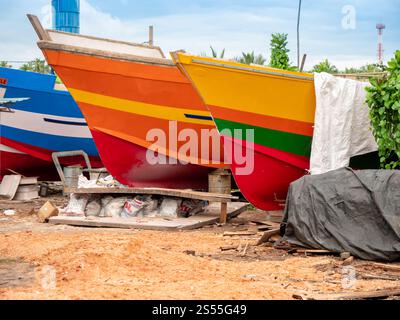 Colorful fishing boats float in a serene harbor, with white buildings ...