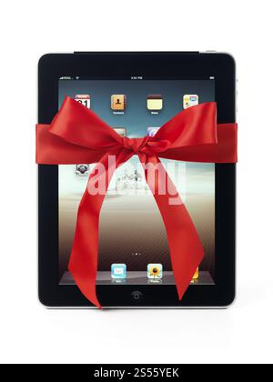 tablet wrapped in red ribbon, paper notebook, pen on white vintage ...