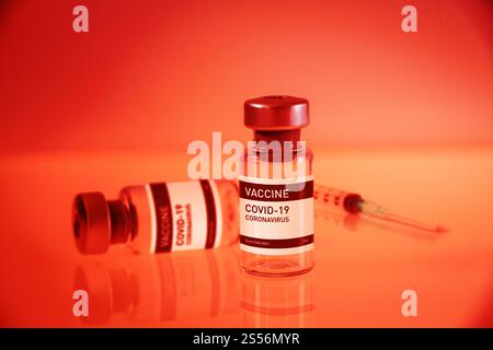 Syringe and drug bottle on red background Stock Photo - Alamy