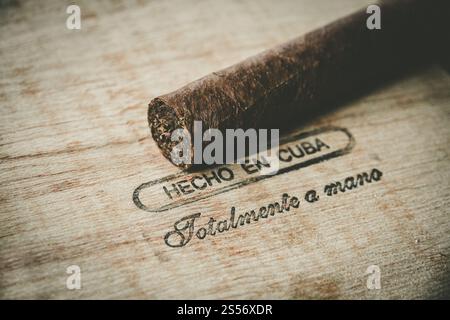 Brown cuban cigar on vintage wooden box with inscription in spanish ...
