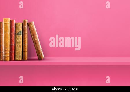 Row of old books on pink shelf. Horizontal background scene Stock Photo ...