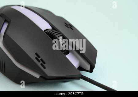 Closeup of a black gaming optical mouse on a blue background. Device ...
