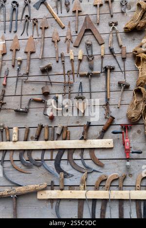 A wall full of tools and implements, including a red and black wrench ...