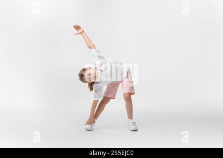 Cute little girl exercising on white background Stock Photo - Alamy