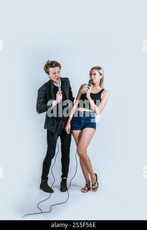 Happy portrait of Couple holding microphone and sing a song Stock Photo ...