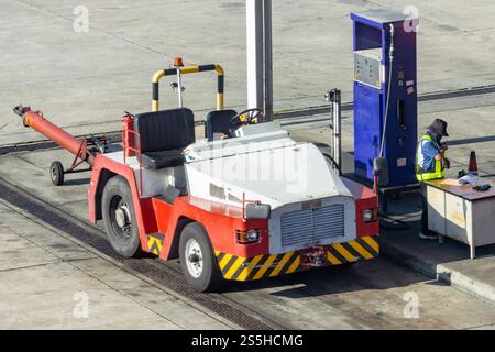 Tow tractor pulling luggage carts at airport apron Stock Photo - Alamy