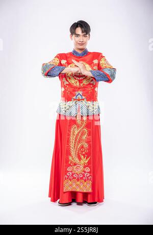 A man wear cheongsam is standing and respect customer who come to shop ...