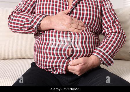 Overweight man in tight shirt on white background, closeup Stock Photo ...