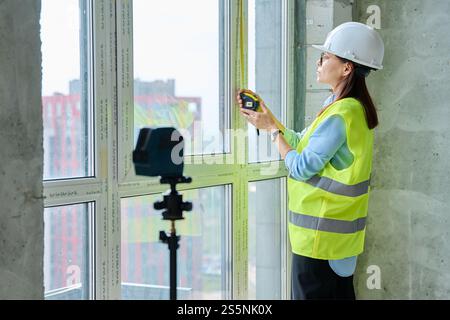 Industrial worker, woman measuring window with tape measure at ...