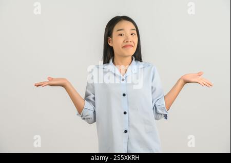 Clueless young woman with an indifferent face expression shrugging her ...