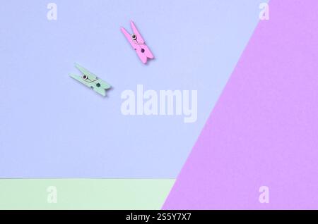 Two colored wooden pegs lie on texture background of fashion pastel ...