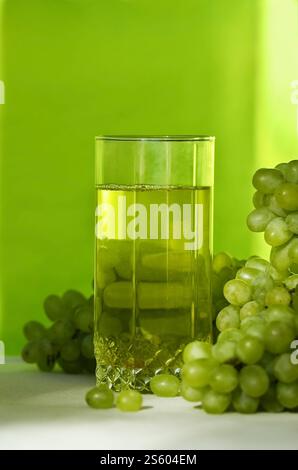 Yellow grape juice and wet bunches of green grapes Stock Photo - Alamy