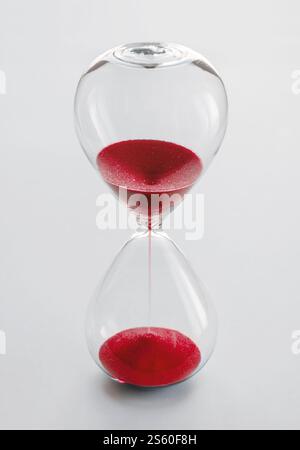 Hourglass with red flowing sand isolated on white Stock Photo - Alamy