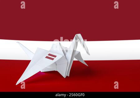 Latvia flag depicted on paper origami airplane. Oriental handmade arts ...