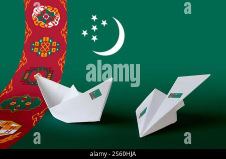 Turkmenistan flag depicted on paper origami crane wing. Oriental ...
