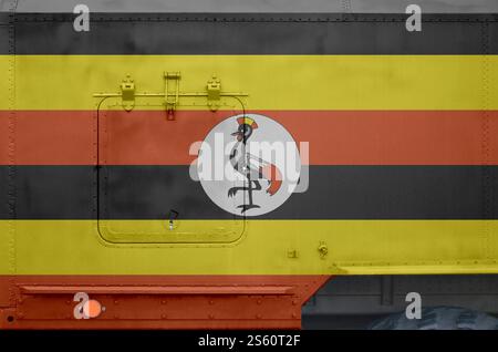 Uganda flag depicted on side part of military armored helicopter close ...