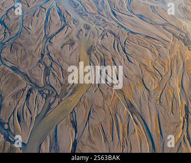 Aerial view of braided river channels carve through contrasting ...